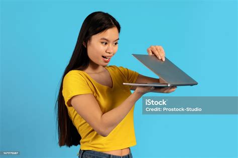 노란 티셔츠를 입은 쾌활한 호기심 예쁜 밀레니얼 중국 여자 학생이 노트북을 열다 열기에 대한 스톡 사진 및 기타 이미지 열기 놀라움 여자 Istock