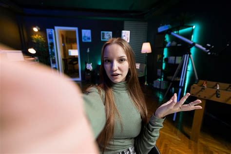 홈 스튜디오에서 라이브 스트리밍 중에 충성스러운 관객과 연결하는 소녀의 Pov 무료 사진