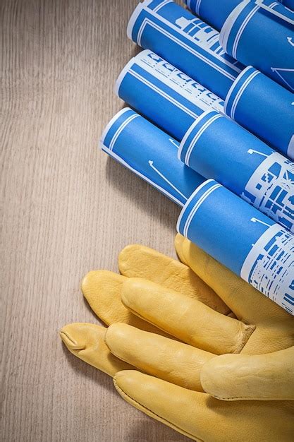 Dibujos de ingeniería azul guantes de seguridad en concepto de construcción de tablero de madera