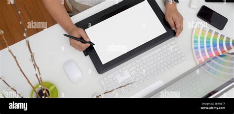 Overhead Shot Of Designer Working On Mock Up Tablet Computer Device Smartphone And Colour