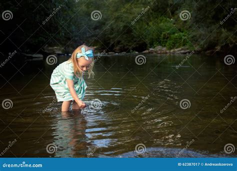 Adorable Blond Girl Playing In River Exploration Concept Stock Image
