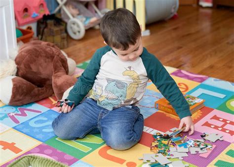 Little Boy Playing With Toys And Puzzles In His Room Stock Image