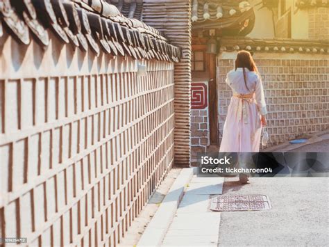 한국에서 전통 옷 빈티지 마을과 소프트 포커스 배경 가진 오래 된 벽돌 벽에 뒷면 긴 머리 여자에서 여행 및 관광 아시아 개념