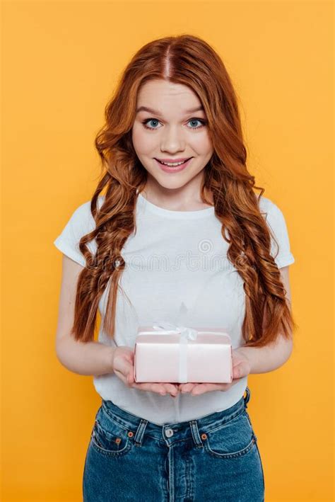 Beautiful Redhead Girl Looking At Camera And Holding T Box Isolated