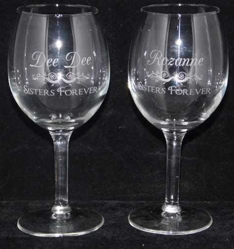 Two Wine Glasses Sitting Next To Each Other On A Black Tableclothed