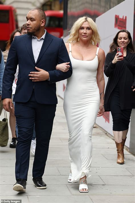 Kesha Struggles To Contain Her Ample Cleavage In A Plunging White Dress