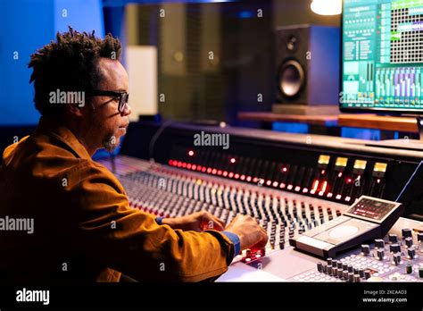 African American Sound Technician Using Audio Console With Moving