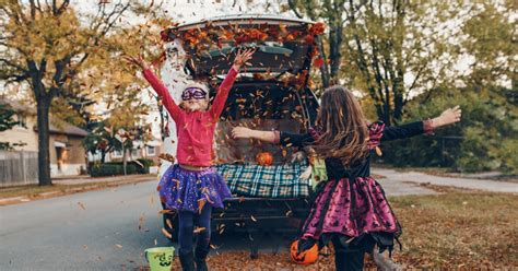 트릭 또는 트렁크 어린이 형제 자매는 차 트렁크에서 할로윈을 축하합니다 10 월 휴일 야외를 준비하는 친구 어린이 소녀