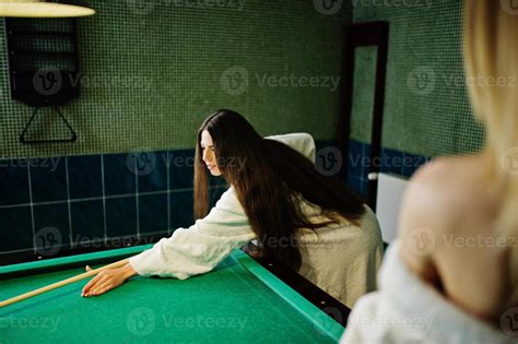 Dos Chicas Sexy En Albornoz Blanco Y Traje De Baño Juegan Al Billar