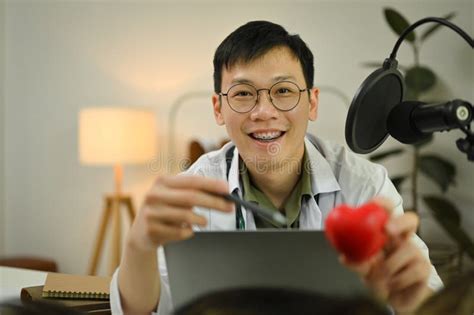 Doctor Using Microphone And Laptop Computer To Recording Audio About Medication Advise