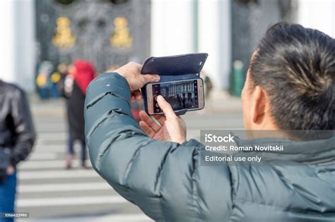 아시아 외관의 남자 관광 사진을 스마트폰에 암 자에는 궁전 광장의 세인트 피터 스 버그 러시아 9 월 2018 건물 뒤에서 보기