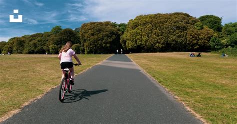 낮 동안 회색 콘크리트 도로에서 자전거를 타는 분홍색 셔츠를 입은 소녀 사진 Unsplash의 무료 세인트 앤스 파크 이미지
