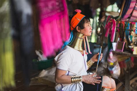 A Long Neck Tribal Woman Sitting Inside Her Silk Bazar By Stocksy