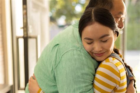 Hugging Warmly Asian Father And Daughter Sharing Tender Moment At Home