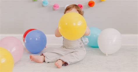 그의 첫 번째 생일을 축하하는 재미있는 백인 아기 아이 아이 유아는 화려한 풍선으로 바닥에 앉아 있습니다 집에서 실내에서 이벤트 또는 파티를 축하합니다 생일 축하