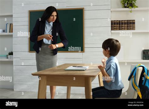 Teacher Pointing On Wrist Watch While Scolding Pupil For Being Late In