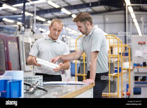 Workers Discussing Component In Engineering Factory Stock Photo Alamy