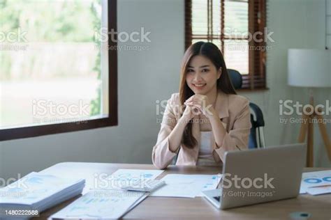 직장에서 컴퓨터와 재정 예산 문서를 사용하여 사업을 성공적으로 투자 한 행복한 미소 짓는 얼굴을 보여주는 여성 사업주의 초상화