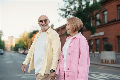 Happy Elderly Couple Holding Hands While Crossing On The Pedestrian