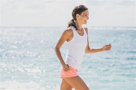 Sporty женщина Jogging с небесами и морем на предпосылке Стоковое Фото