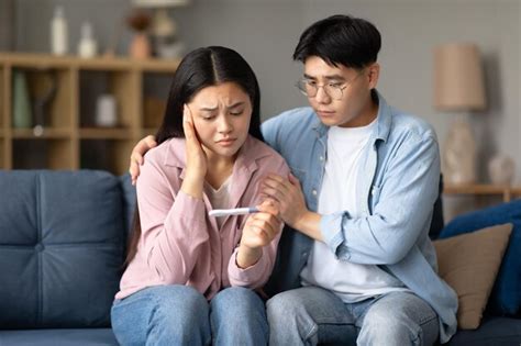 Premium Photo Depressed Korean Couple Holding Negative Pregnancy Test
