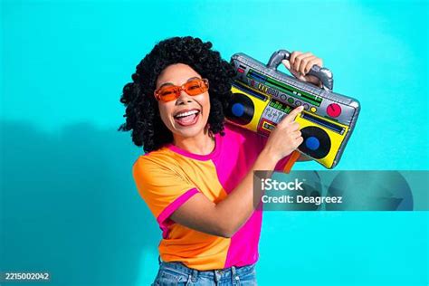 활기찬 젊은 여성이 화려한 풍선 붐 박스를 들고 웃으며 복고풍 분위기를 즐기고 청록색 배경에 서 있습니다 25 29세에 대한 스톡 사진 및 기타 이미지 Istock