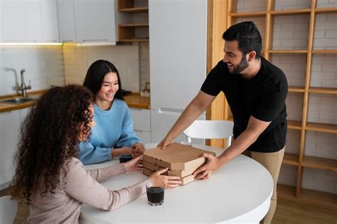 Amis Mangeant De La Pizza à La Maison Ensemble Photo Gratuite