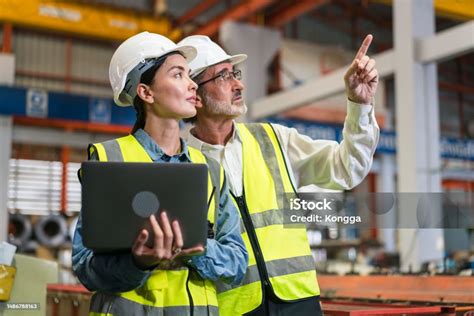 프로젝트 관리자와 엔지니어는 공작물을 검사하고 공장의 제품 및 안전에 대한 표준 및 안전성을 확인합니다 기술자와 여성 노동자가 공장에서 회의에 대해 이야기하고 있다 2명에