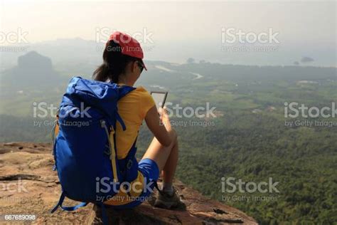 성공적인 여성 등산객 은 산 봉우리에 전자 책 하이킹을 읽고 가장자리에 대한 스톡 사진 및 기타 이미지 가장자리 관광객