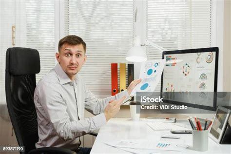 당황한 충격 그리고 스트레스 사업가 셔츠 책상에 앉아 현대 모니터 폴더 커피 문서 창 배경에 빛 사무실 컴퓨터에서 작업 관리자