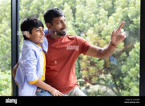 Indian Father And Son Sitting Together Indian Father Pointing At