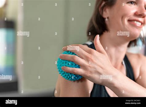 Young Woman Massages Her Shoulder With An Mfr Ball Myofascial Roll