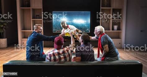 팬 들의 그룹 축구 순간 Tv와 거실에서 소파에 앉아 목표 축 하에 보고 있다 Soccer Tournament에 대한 스톡 사진