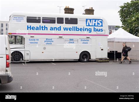 A Man In Shorts Walks To Nhs Bus Offering Health And Wellbeing Services