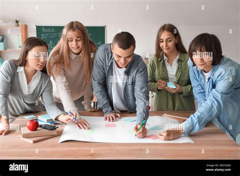 Group Of Teenage Babes Performing Task At Table In Classroom Stock Photo Alamy