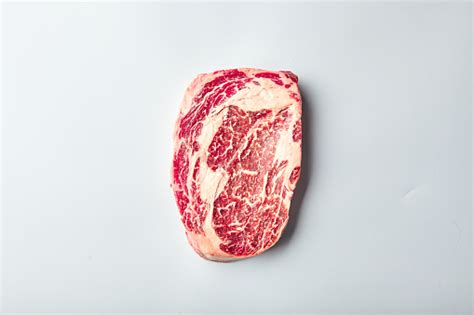 대리석으로 된 곡물 을 먹인 쇠고기의 Rrib Eye 스테이크는 흰색 배경에 놓여 있습니다 애버딘 앵거스 소에 대한 스톡 사진