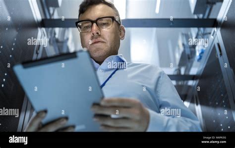 server technician working in data center they walk through working rows of server racks stock