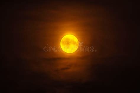 Bright Full Moon Glowing In Dark Night Sky Surrounded By Thin Clouds