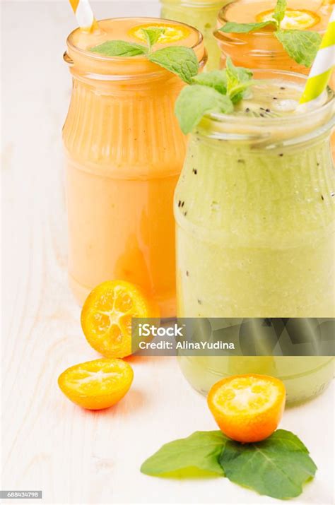 갓 혼합된 오렌지 금 귤과 짚 민트 잎 익은 베리 컷 유리 항아리에 그린 키 위 과일 스무디 닫습니다 화이트 나무 보드 배경 수직입니다 0명에 대한 스톡 사진 및 기타