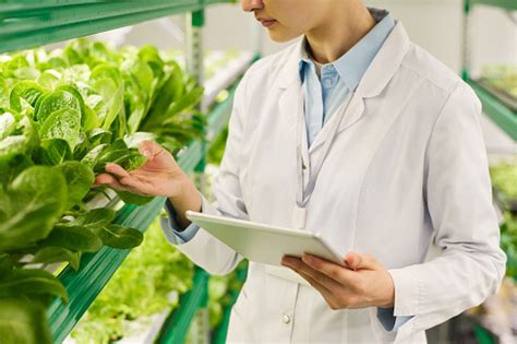 실험실 가운을 입은 젊은 여성 연구원이 수직 트러스 옆에 서 있다 25 29세에 대한 스톡 사진 및 기타 이미지 25 29세 Stem 주제 과학자 Istock