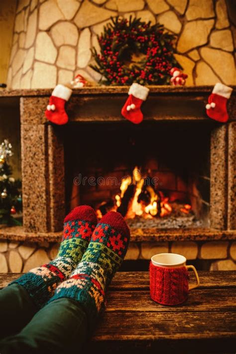 Feet In Woollen Socks By The Christmas Fireplace Woman Relaxes Stock