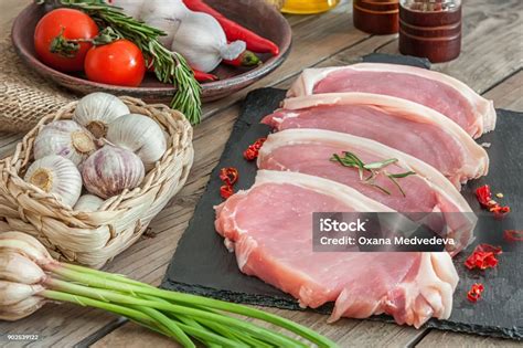 로즈마리와 슬레이트 보드에 굽기 위한 돼지고기 덩어리 고리버들 바구니에 마늘 소박한 스타일의 토마토 0명에 대한 스톡 사진 및
