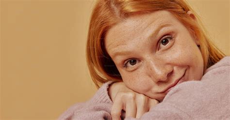 빨간 머리와 파란 눈을 가진 여자가 사진을 위해 포즈를 취하고 있다 사진 Unsplash의 니트 웨어 이미지