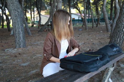 Girl Opens Case Of Bass Musical Instrument On Table In Park Among Trees