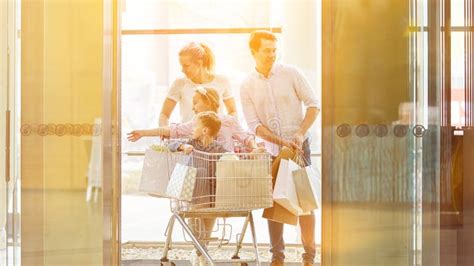 A Fam Lia Empurrar Crian As Na Compra Do Quando Do Carrinho De Compras Foto De Stock Imagem De