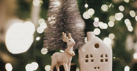 즐거운 성탄절 세련된 크리스마스 트리 순록 장난감 크리스마스 조명을 배경으로 소박한 나무 위의 집 아름 다운 작은