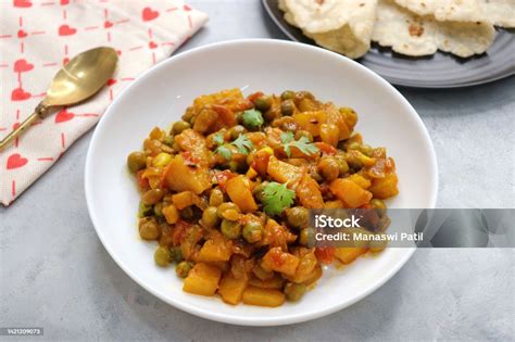 알루 마타르 카레 감자 완두콩은 인도 향신료와 함께 양파와 토마토로 요리했습니다 고수풀 잎으로 장식되었습니다 차파티 또는