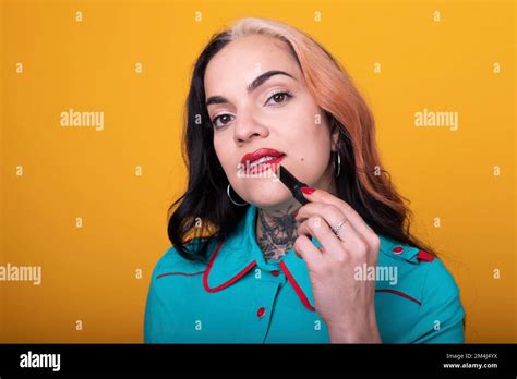 Beautiful Caucasian Woman Applying A Bright Red Color Lipstick On Her