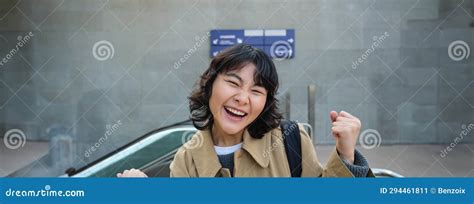 Enthusiastic Asian Girl Stands On Street Makes Hooray Celebration