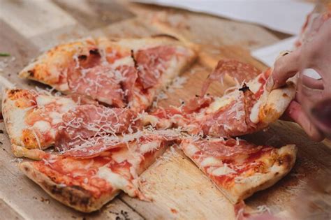 Premium Photo Hands Taking Pieces Or Slices Of Pizza With Tomato